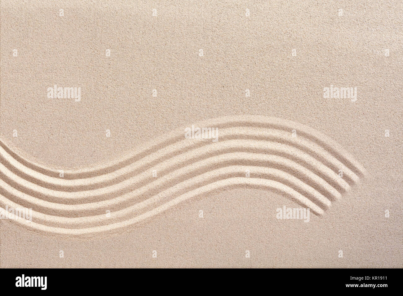 Curving wave pattern raked into smooth manicured sand in a Japanese zen ...