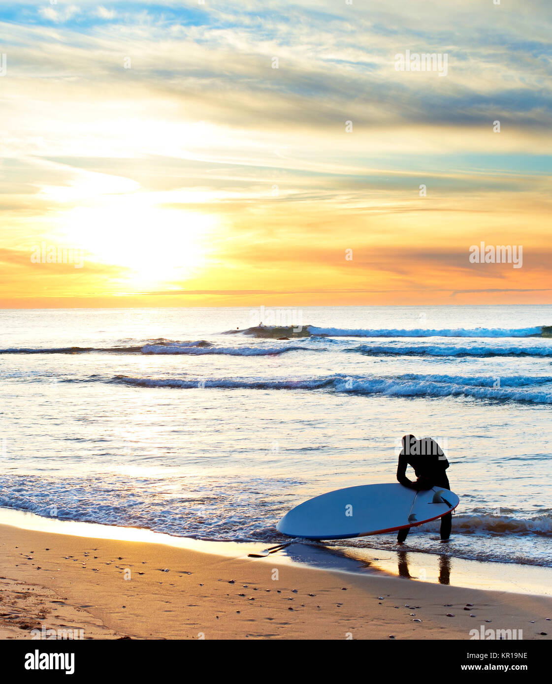 Surfing at sunset Stock Photo - Alamy