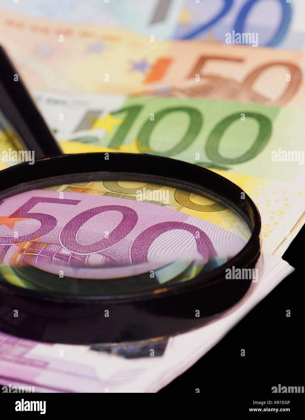 euro banknotes are under a magnifying glass Stock Photo - Alamy