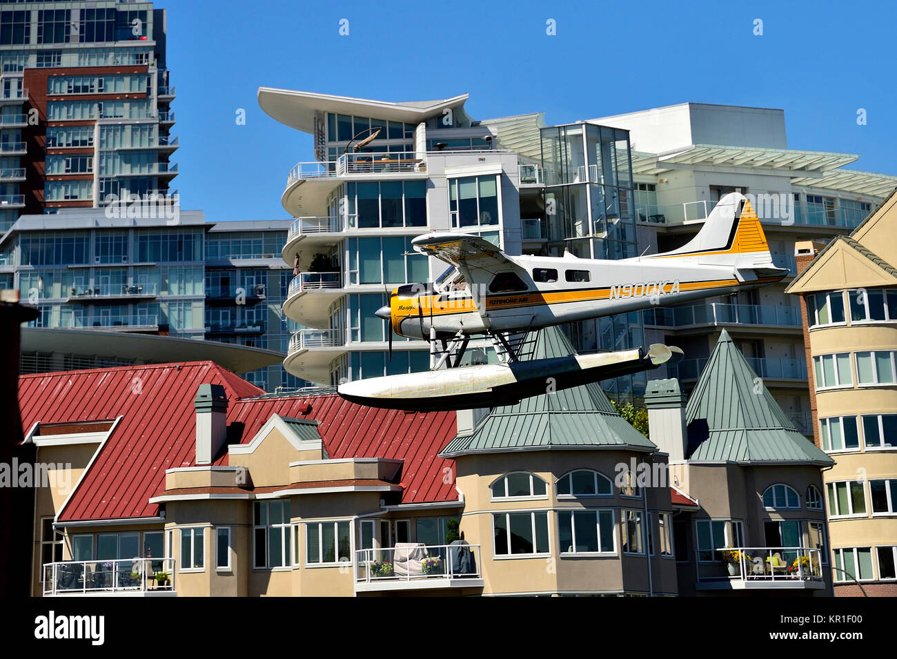 A commuter float plane coming in for a landing in front of a line of ...