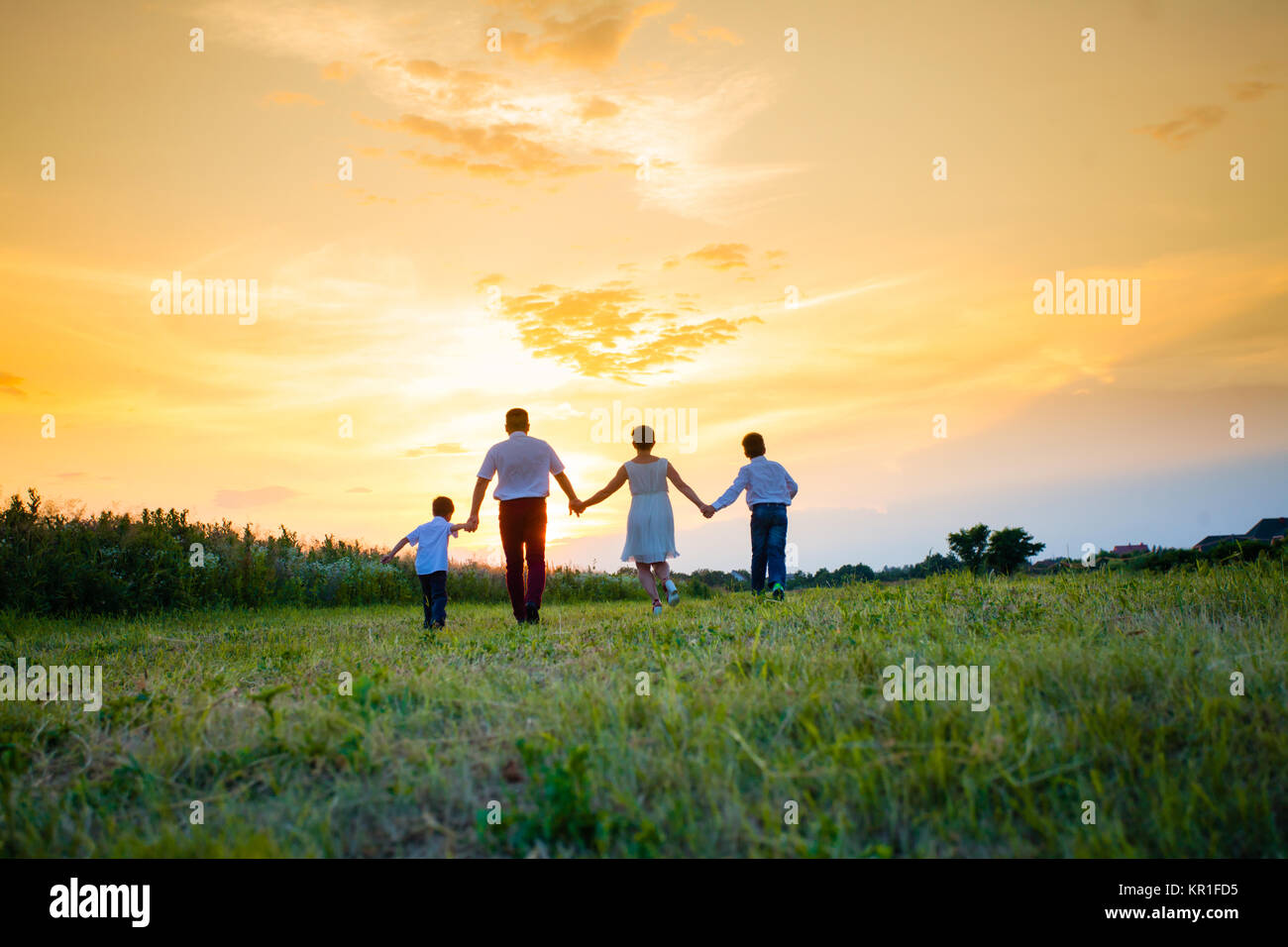 Happy family on the background of the sunset Stock Photo - Alamy