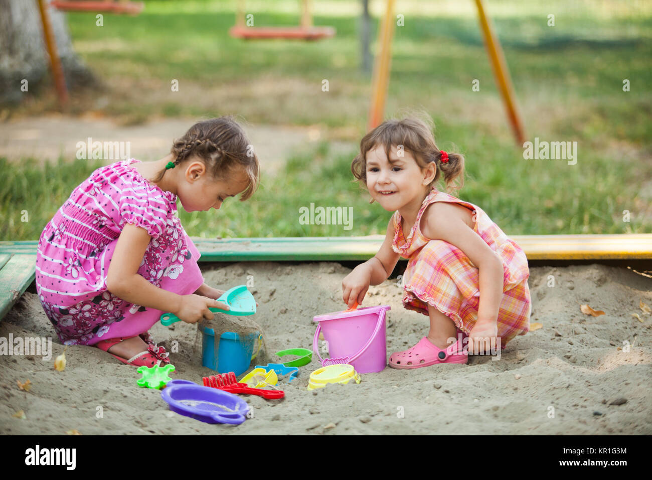 Two girls play in the sandbox Stock Photo - Alamy
