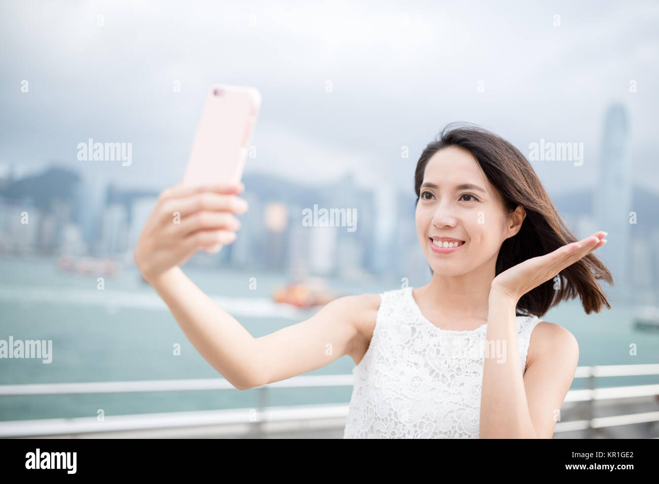 Woman using mobile phone to take selfie Stock Photo - Alamy
