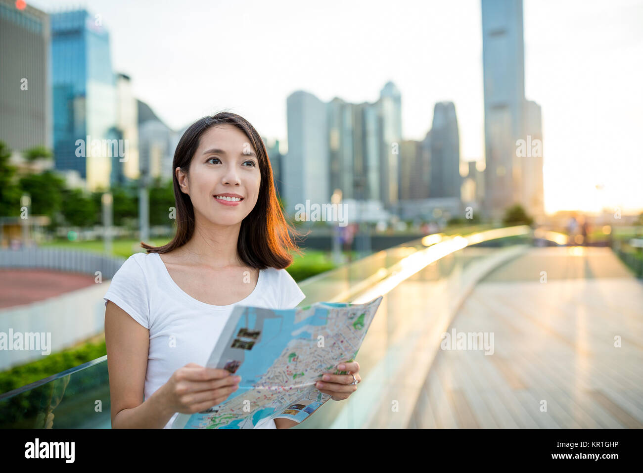 Woman checking paper map under sunset Stock Photo - Alamy