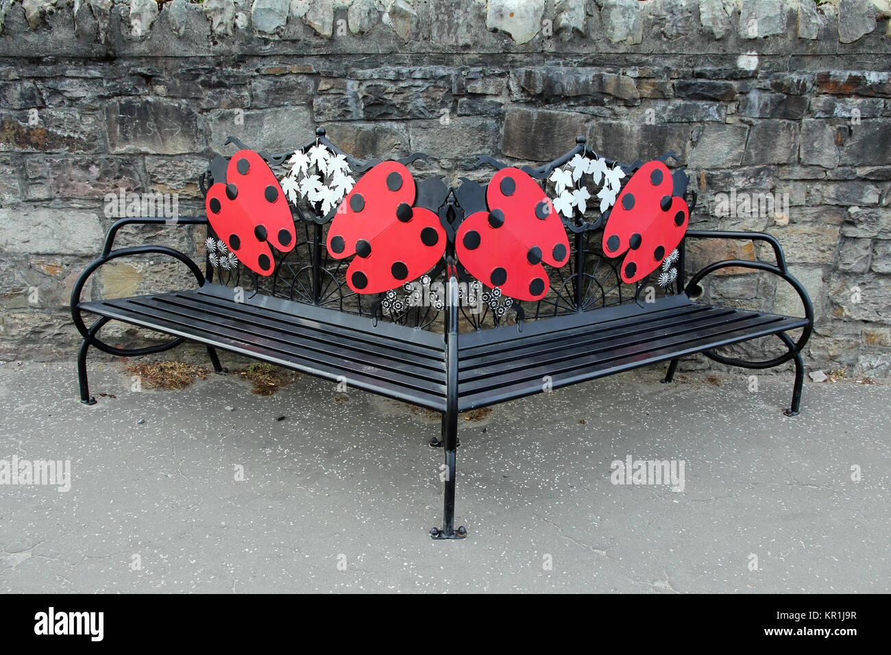 a metal bench with red ladybugs Stock Photo - Alamy