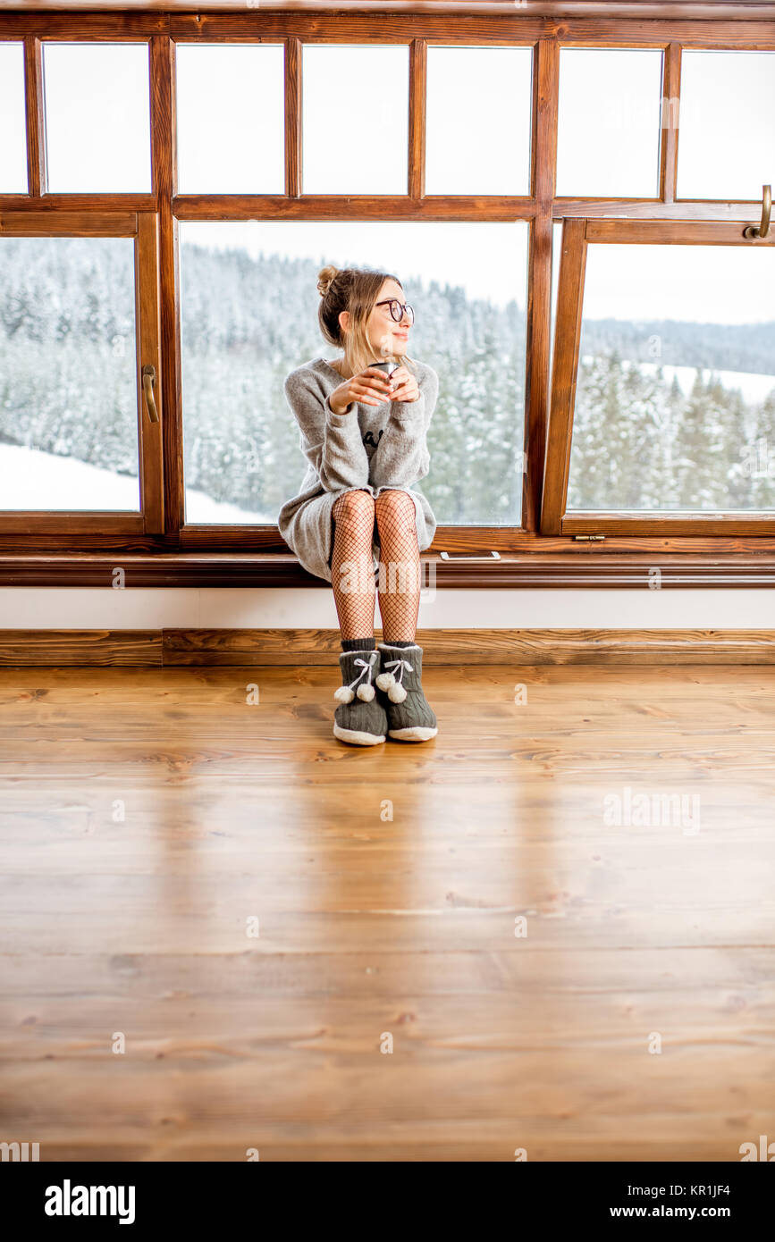 Woman near the window during the winter Stock Photo - Alamy