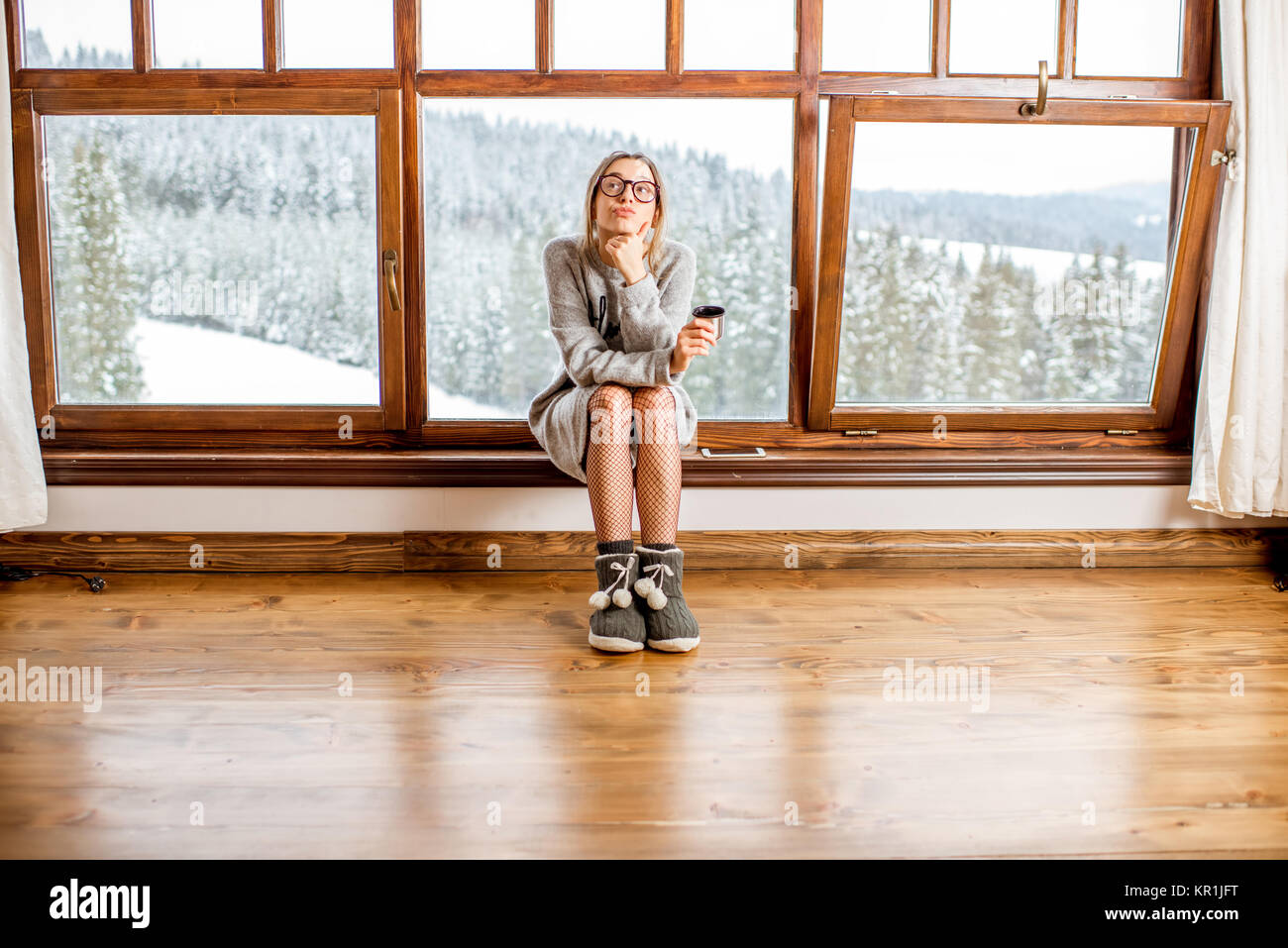 Woman near the window during the winter Stock Photo - Alamy