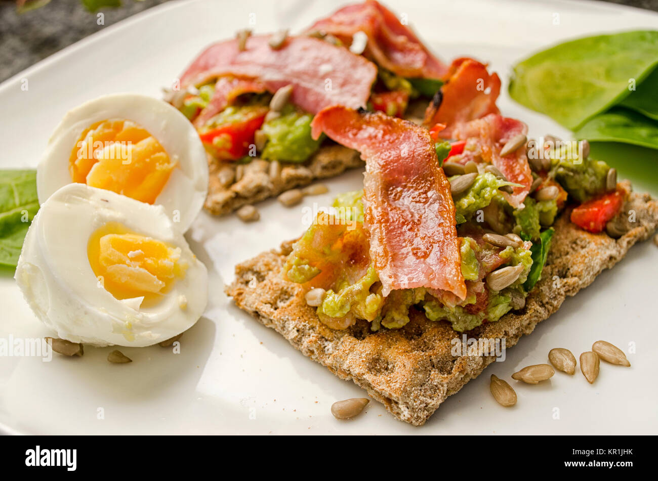 Bacon and Avocado Crispbread with Egg Lunch Stock Photo - Alamy
