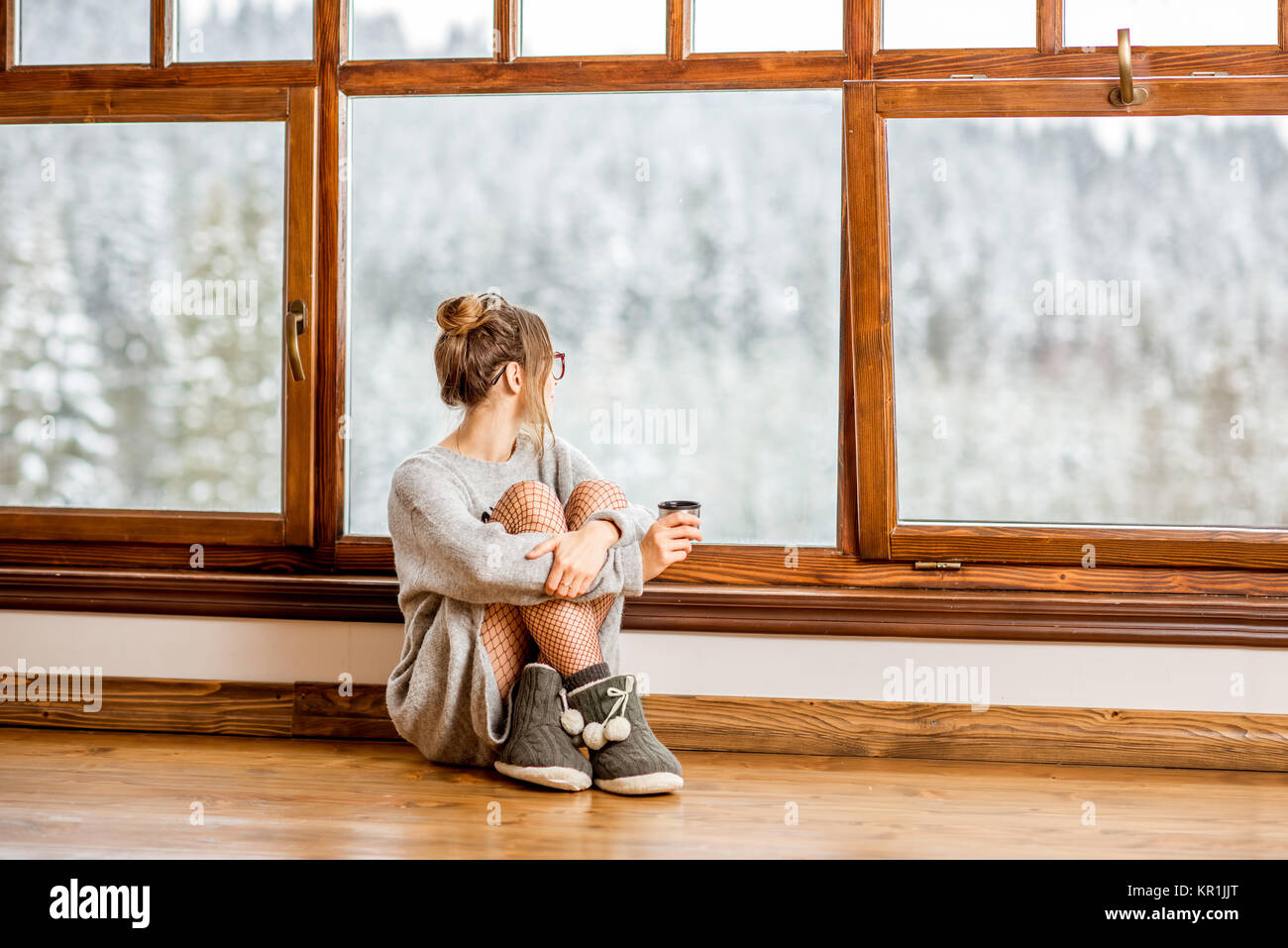 Woman near the window during the winter Stock Photo - Alamy