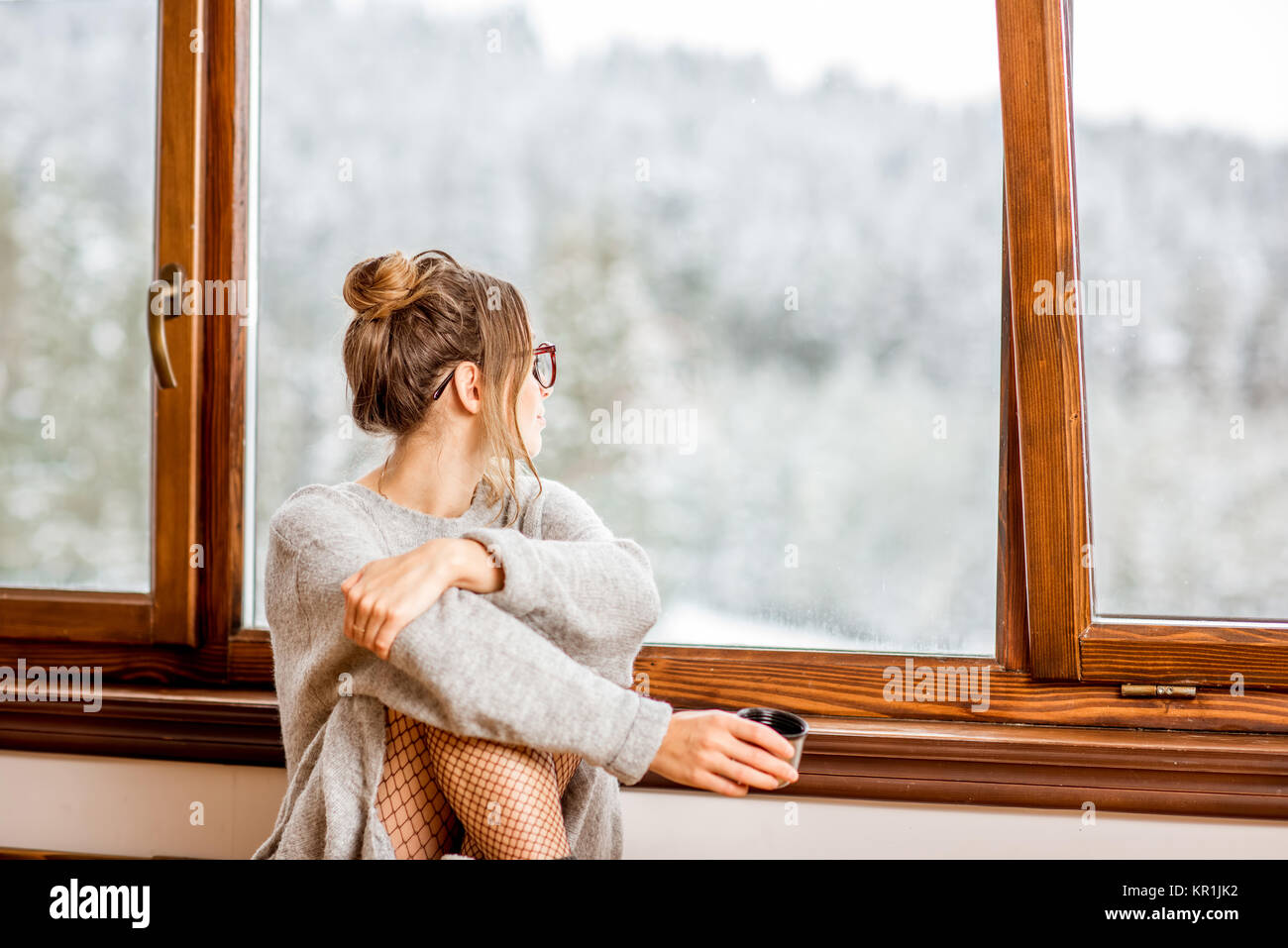 Woman near the window during the winter Stock Photo - Alamy