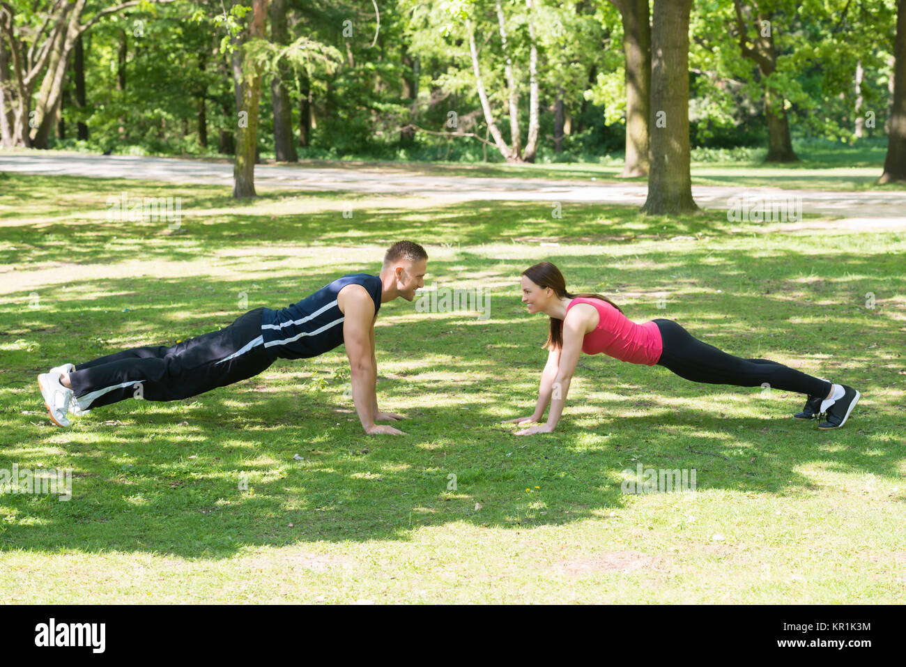 Couple Doing Push-ups In Park Stock Photo - Alamy