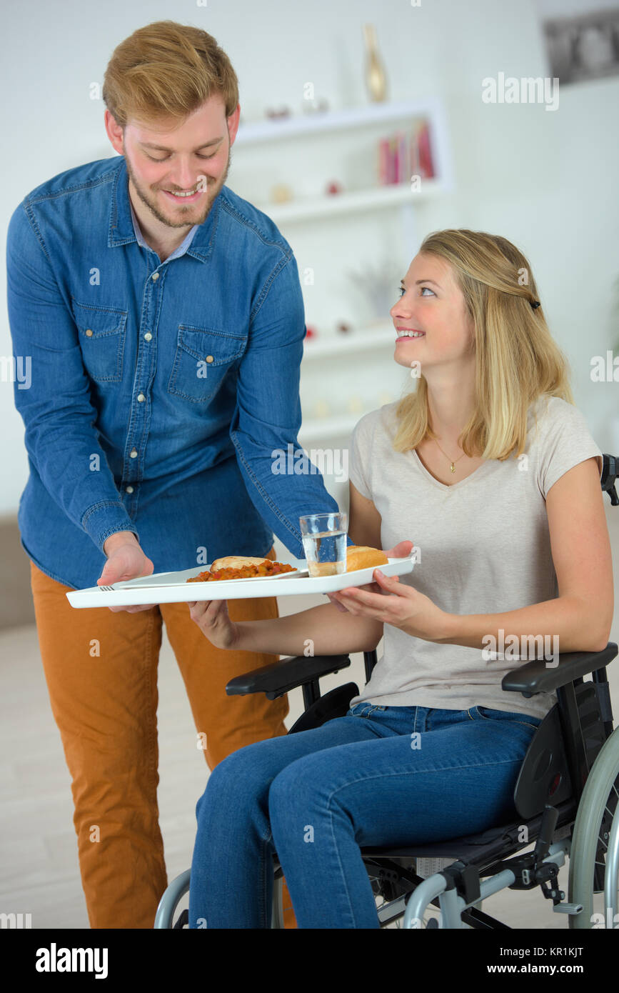 Carer giving lunch to you woman Stock Photo - Alamy
