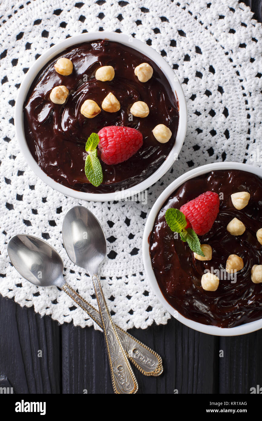 Delicious chocolate pudding with hazelnuts and raspberries close-up in ...