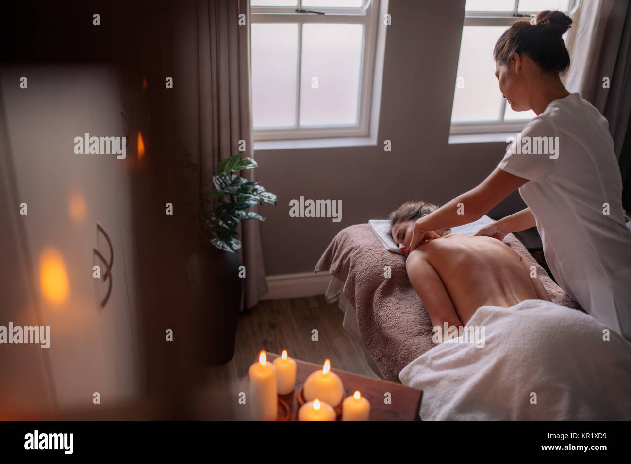 Massage therapist massaging back and shoulders of a woman lying on ...