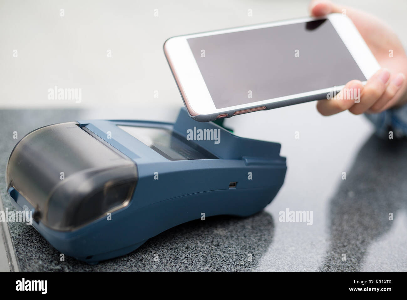 Customer pay with mobile phone on pos terminal Stock Photo - Alamy