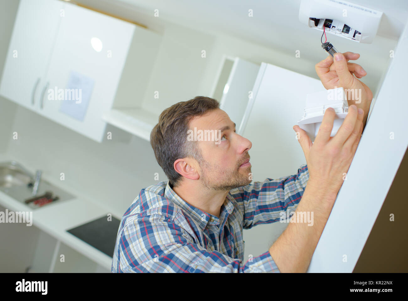 Fitting a smoke alarm in his home Stock Photo - Alamy