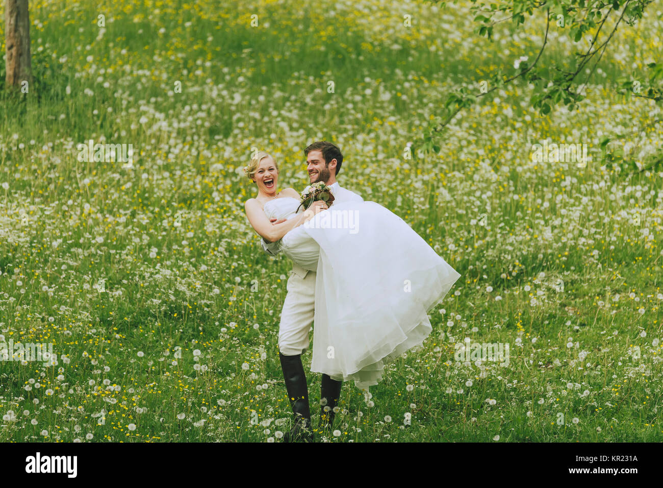 Garden Wedding groom carrying his bride Stock Photo - Alamy
