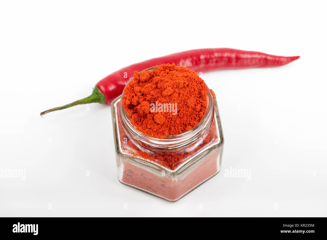 Chili pepper powder in glass jar next to the real chilli Stock Photo ...