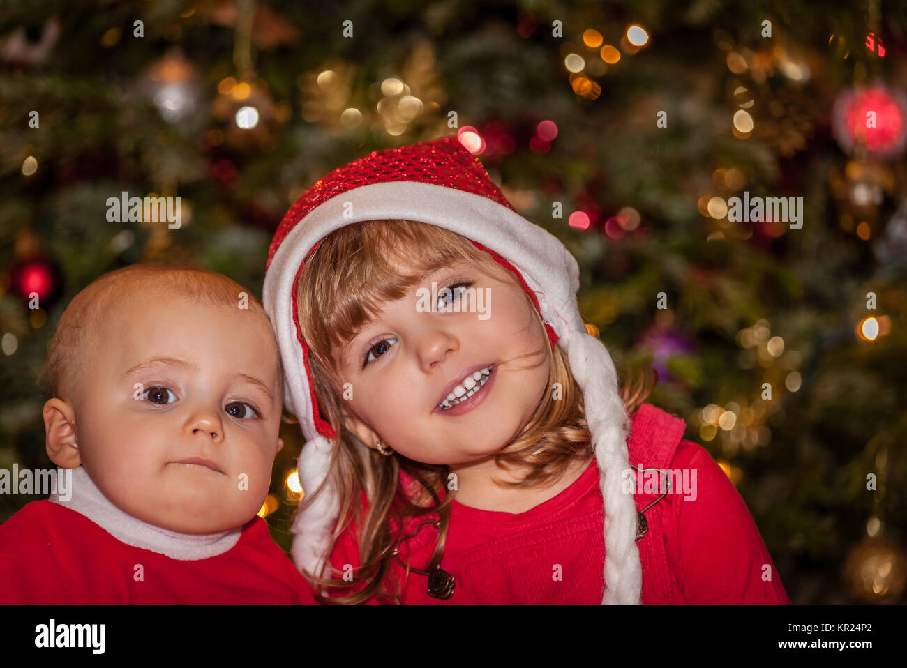 Brother and sister under Christmas tree Stock Photo - Alamy