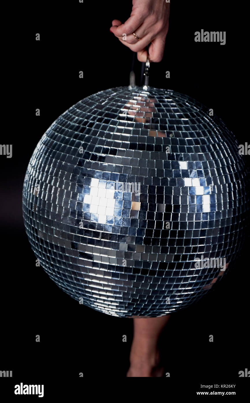 Disco ball in the hands of a woman. A symbol of music, clubs and ...