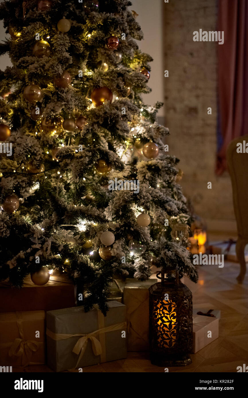 Cozy Christmas tree with Christmas lights and boxes of presents. Warm ...