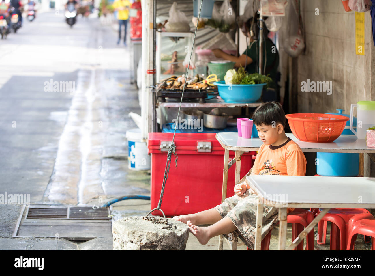 Thailand, Bangkok, Boy playing on the street, people selling or ...
