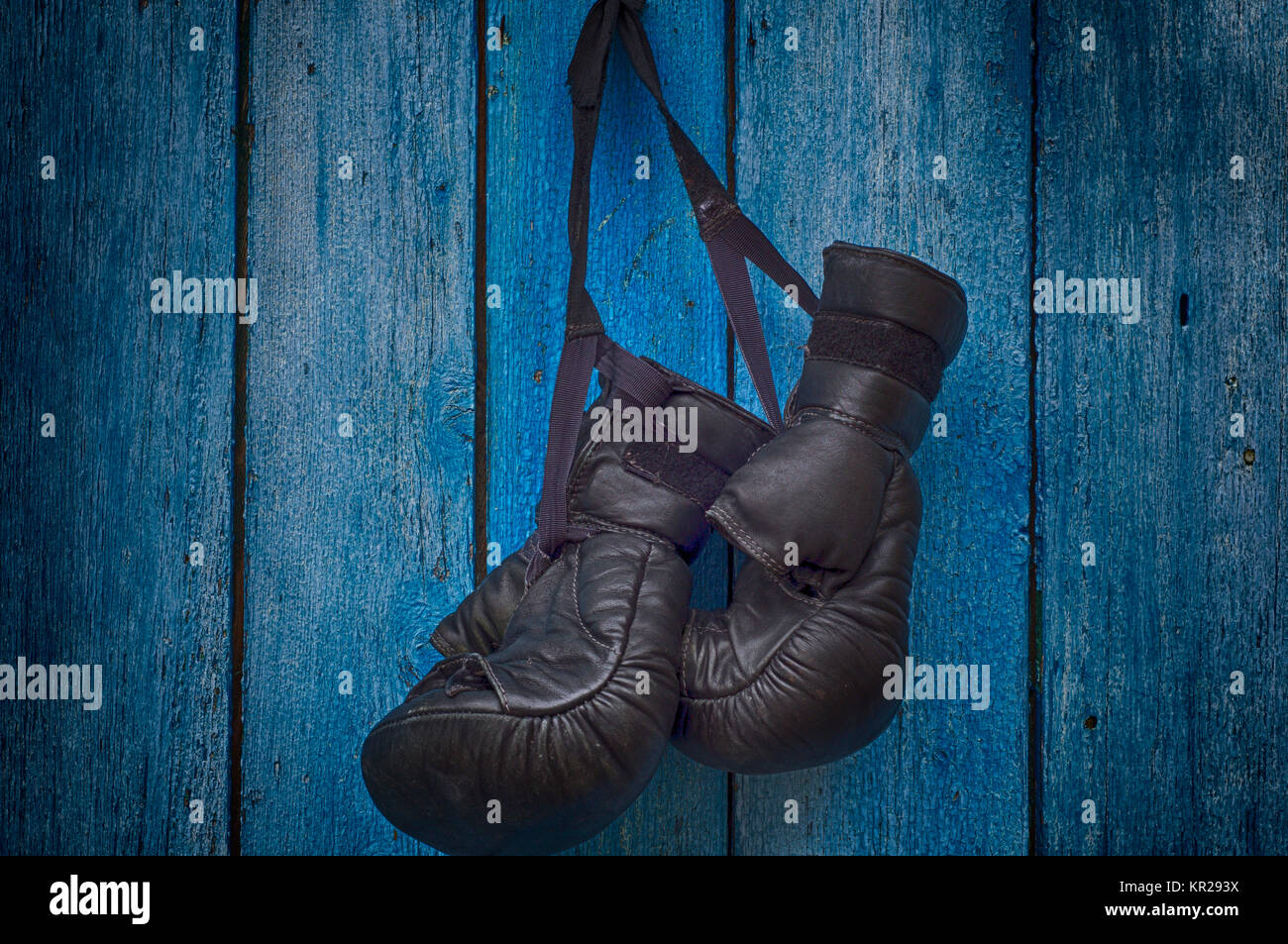 pair of black gloves for Thai boxing hanging on a nail Stock Photo - Alamy