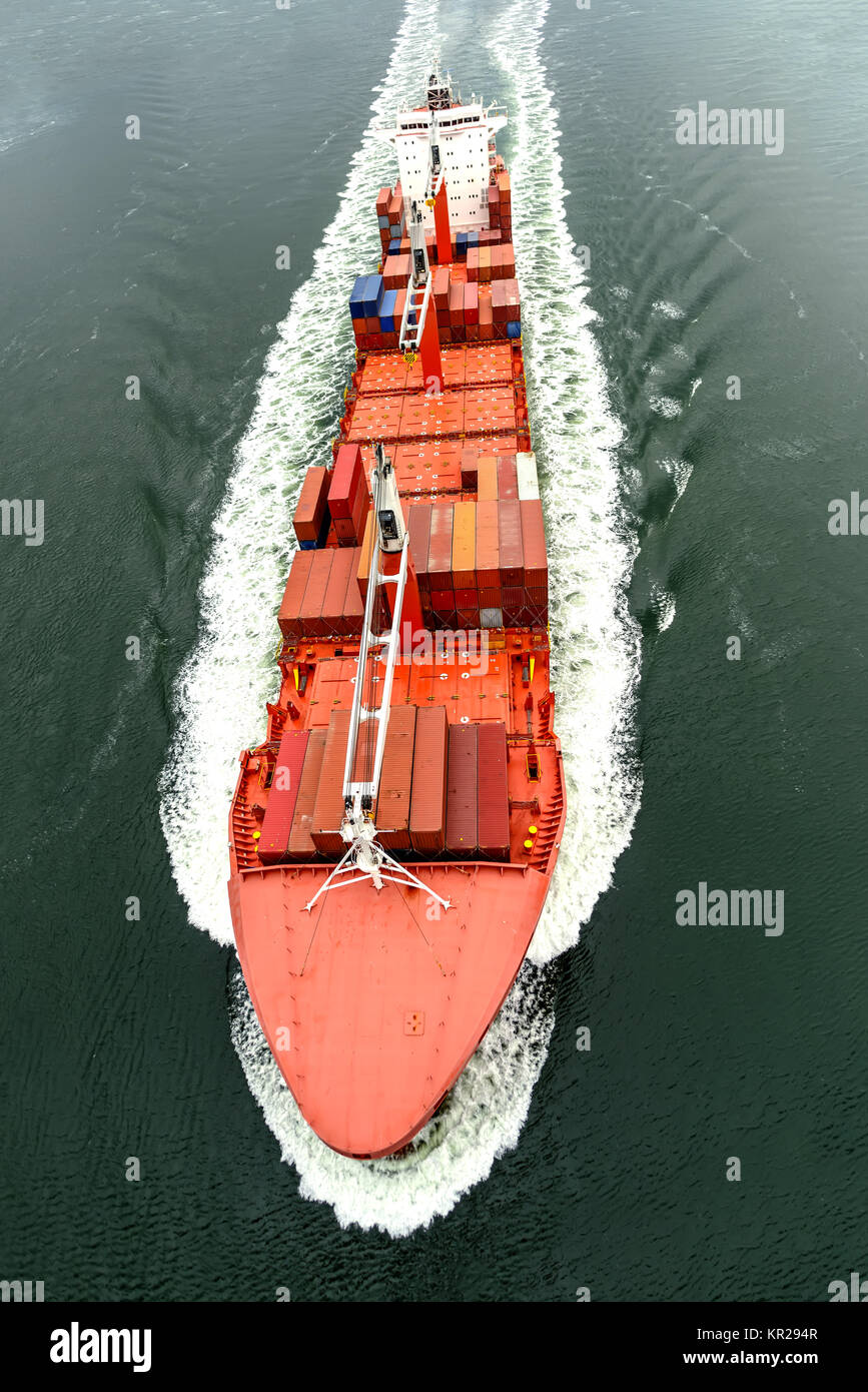 top view of a long modern ship - a container ship floating in the ocean ...