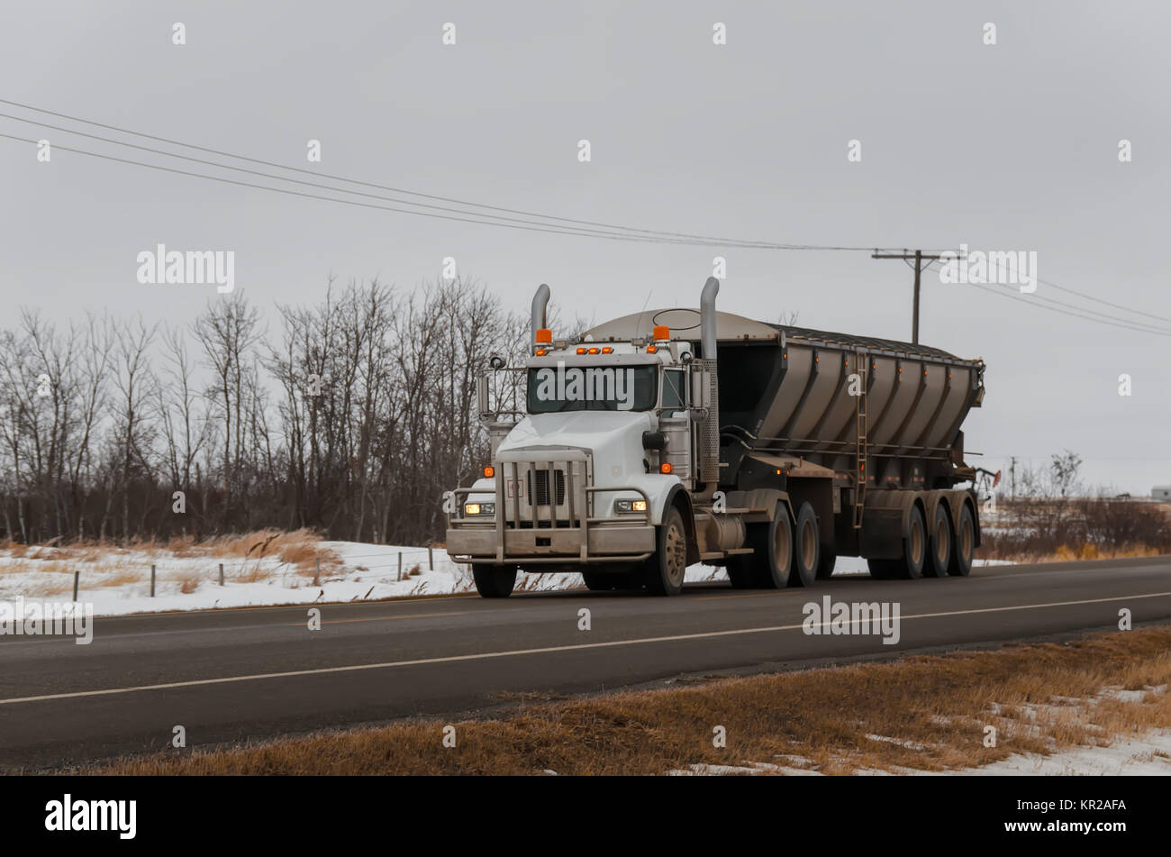 big, lorry, on a winter night stands on the road, with lighted ...