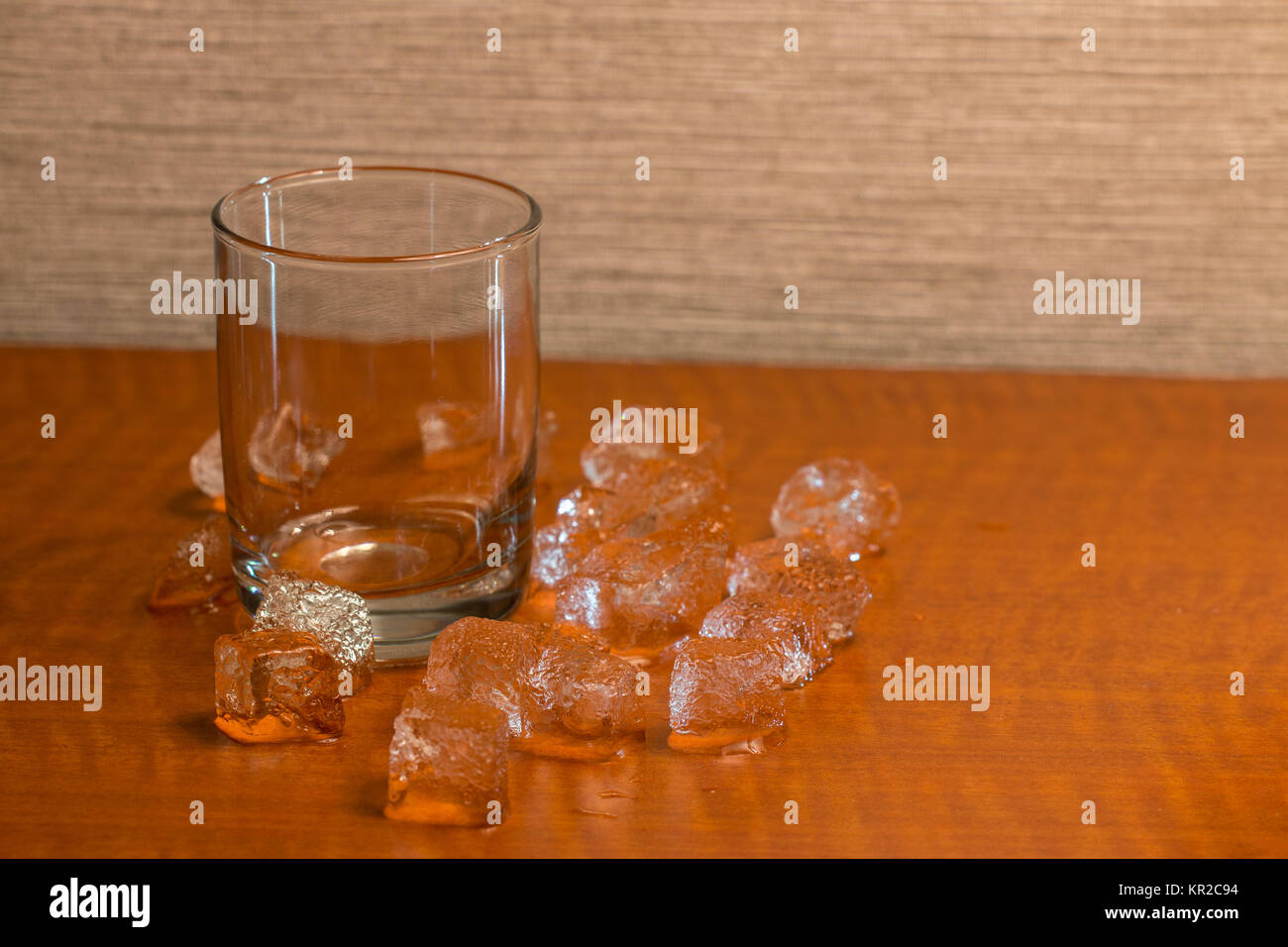 Empty Glass on Wooden Table with Ice Cubes Around it Stock Photo - Alamy