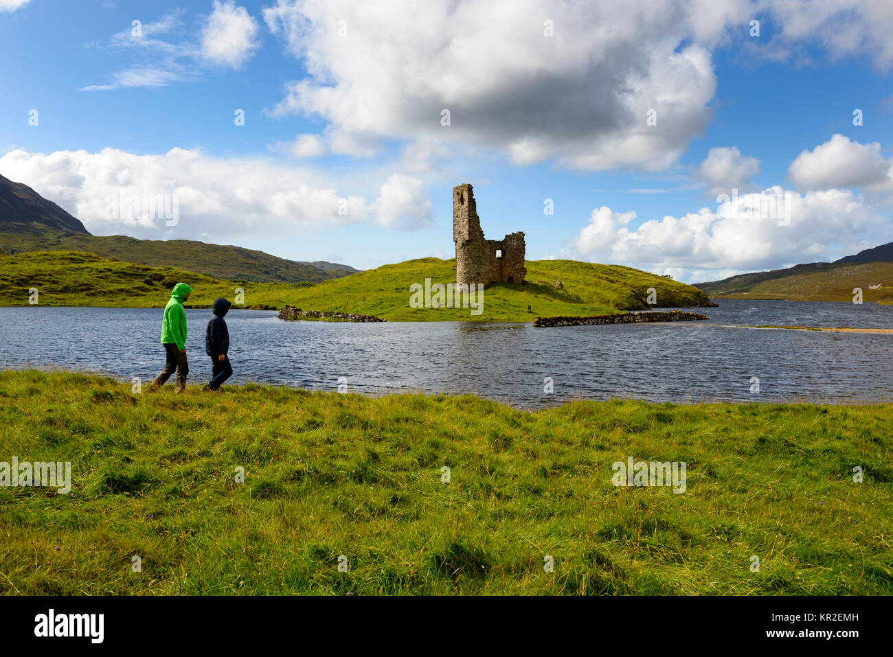 Walker at the ruins of the MacLeods of Assynt, Ardvreck Castle at Loch ...