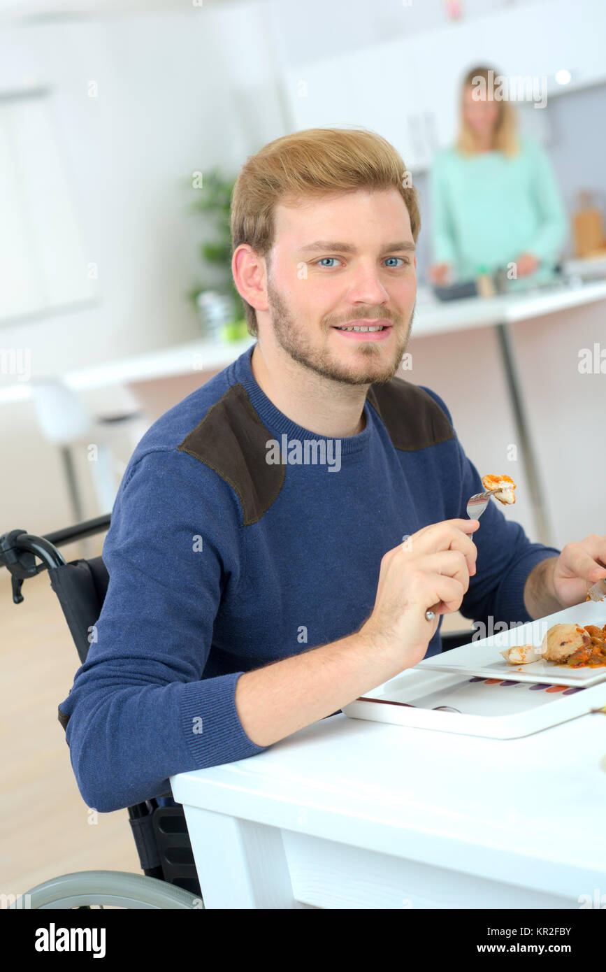 Disabled man sat at the dining table Stock Photo - Alamy