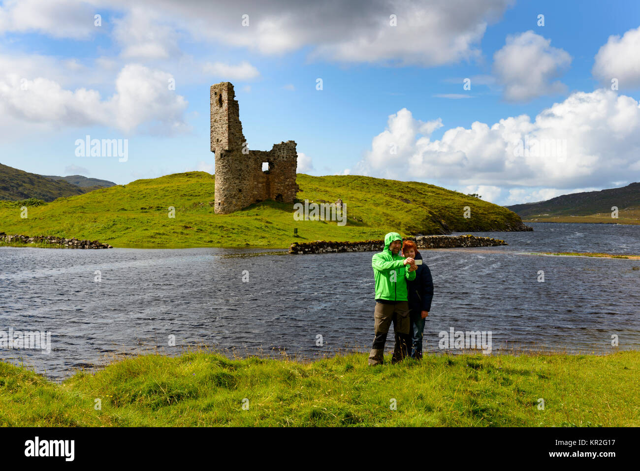 Walker at the ruins of the MacLeods of Assynt, Ardvreck Castle at Loch ...