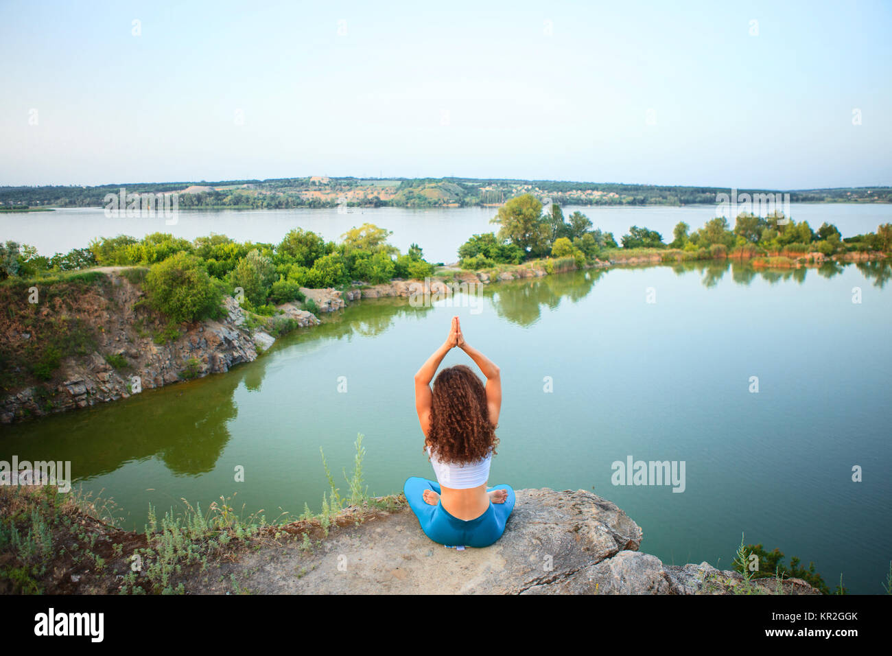 Young woman is practicing yoga near river Stock Photo - Alamy
