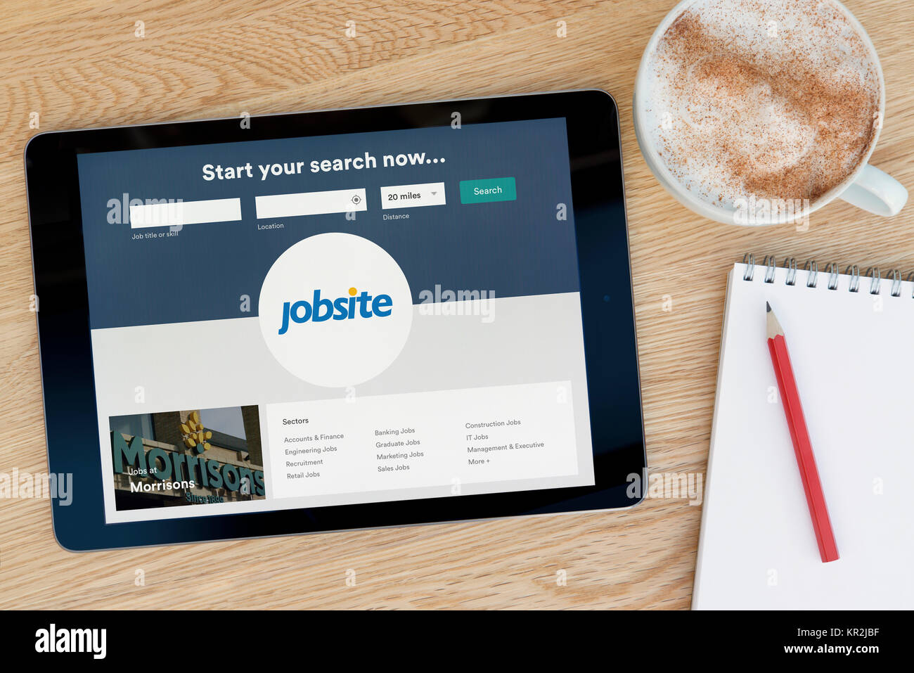 The Jobsite website on an iPad tablet device which rests on a wooden ...