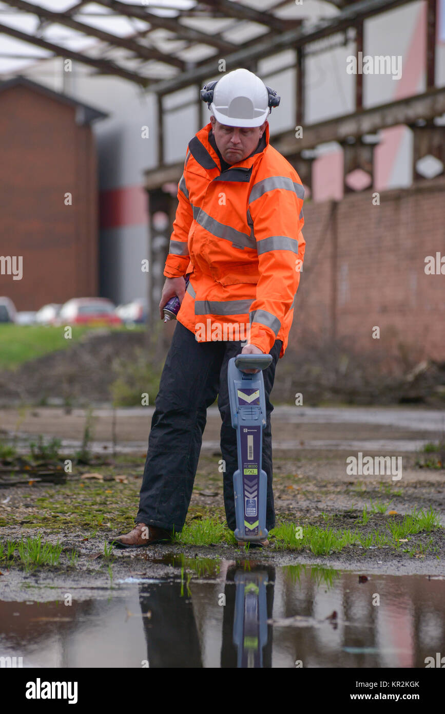 A ground surveyor using technology to detect underground utility pipes ...