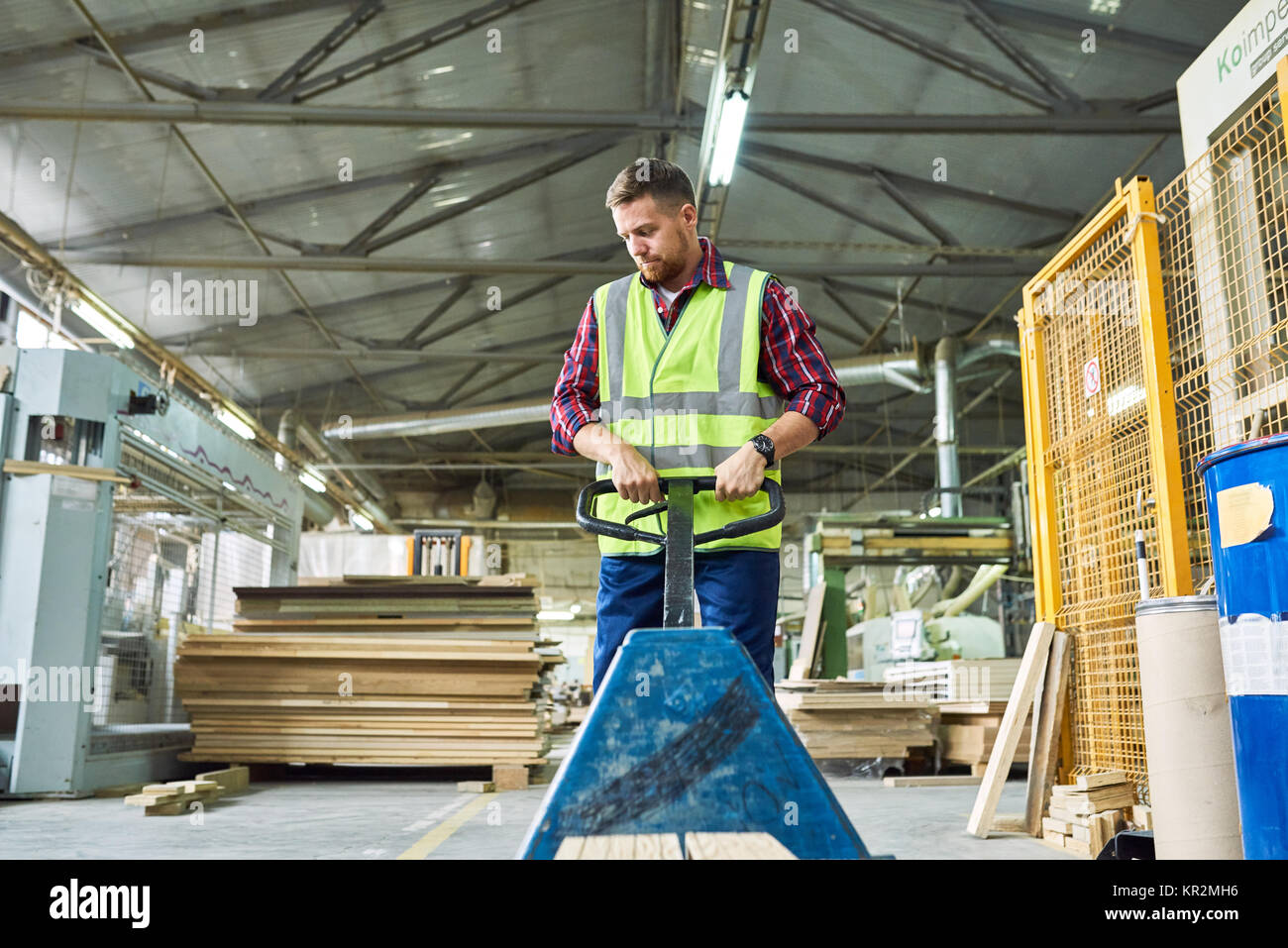 Young Man Moving Cart in Warehouse Stock Photo - Alamy