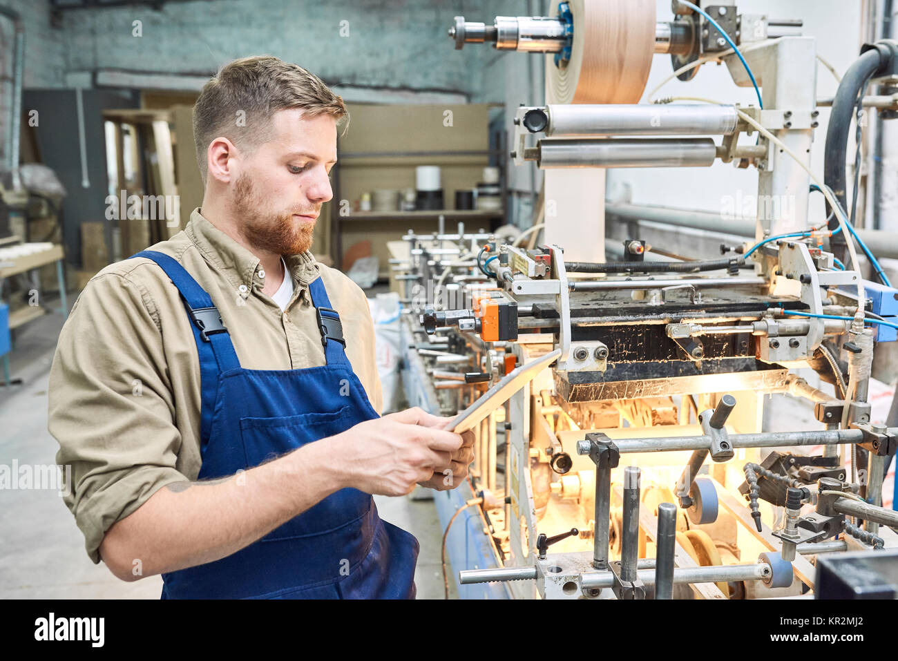 Worker Operating Modern Machine at Factory Stock Photo - Alamy