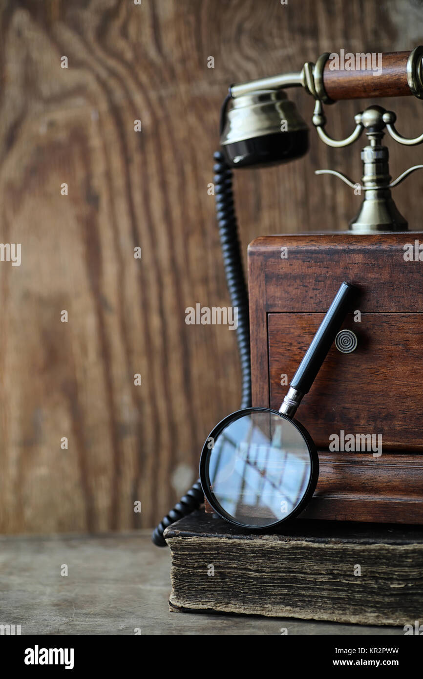 Old telephone and retro book on a wood Stock Photo - Alamy