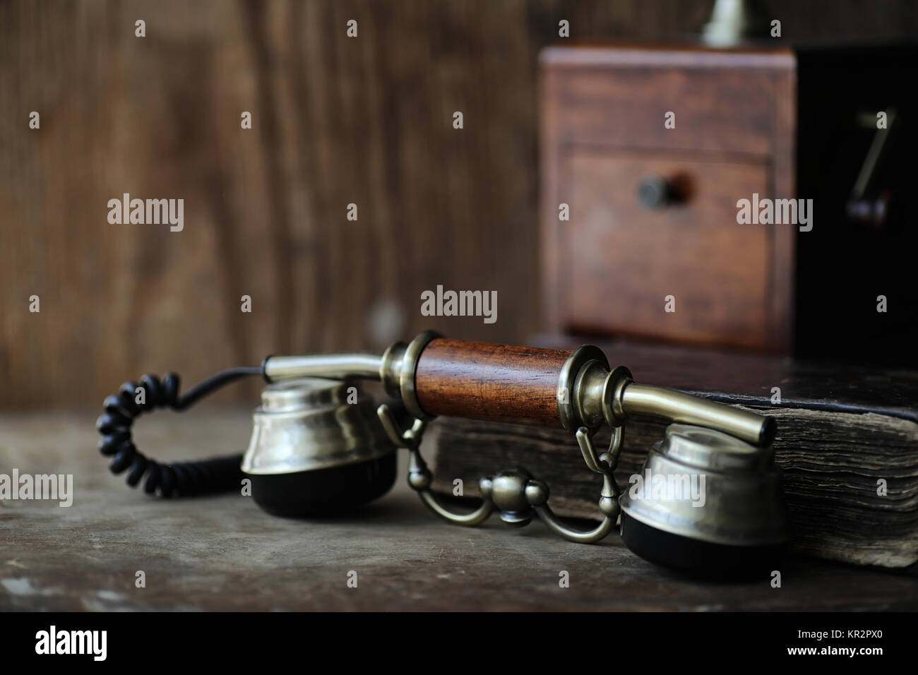 Old telephone and retro book on a wood Stock Photo - Alamy