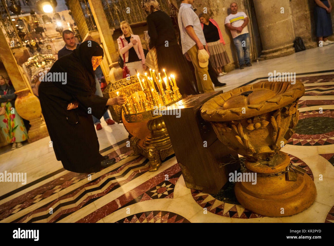 a women lighten a candle for pray in the the Church of the Holy ...