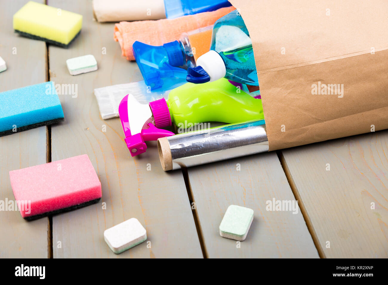 Full paper bag of different house cleaning product on wooden table ...