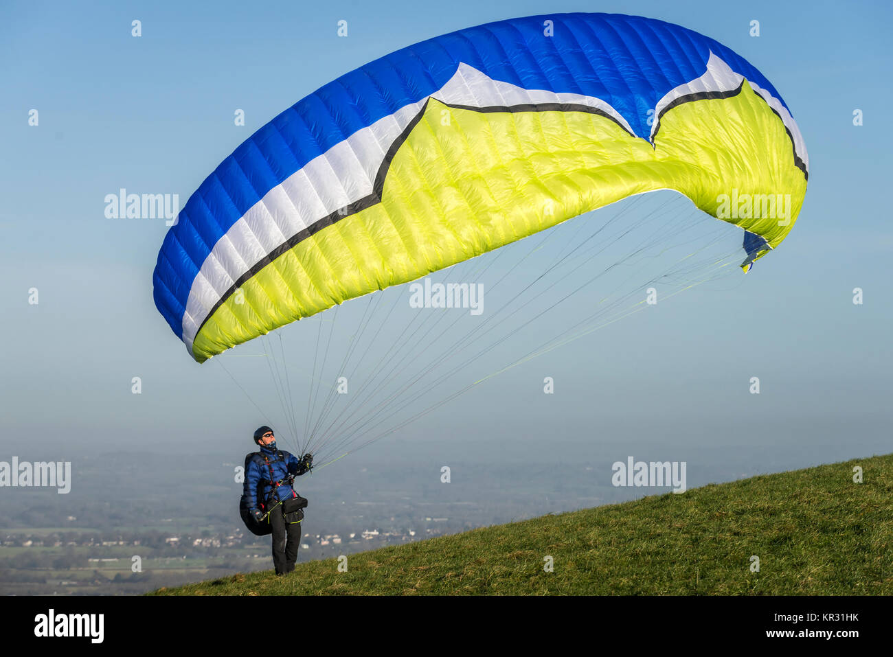 A parascender inflates his chute in preparation for take-off from the ...