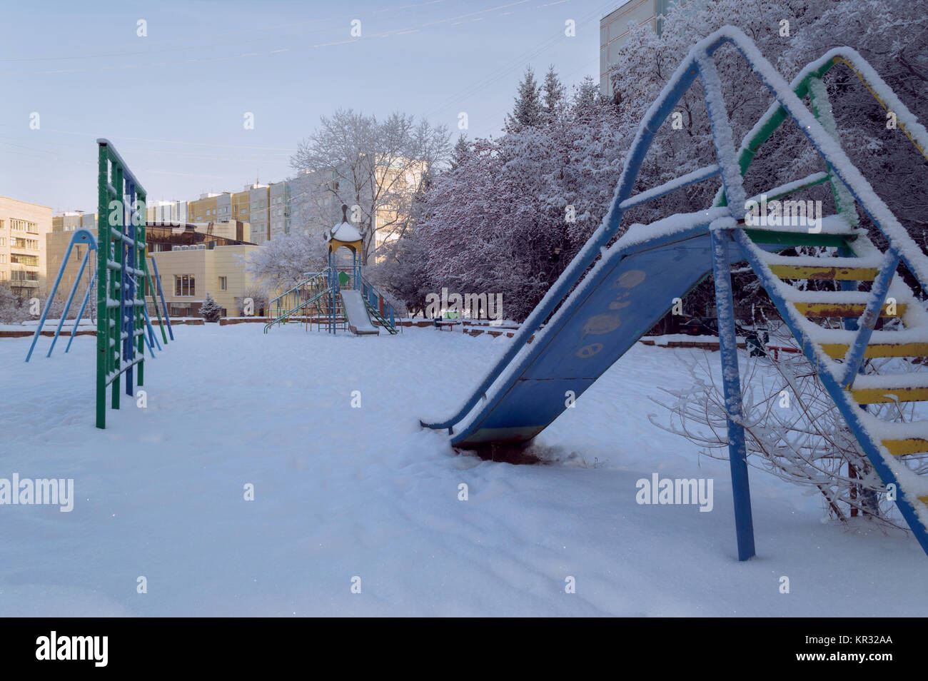 kids playground on winter day with buildings around Stock Photo - Alamy