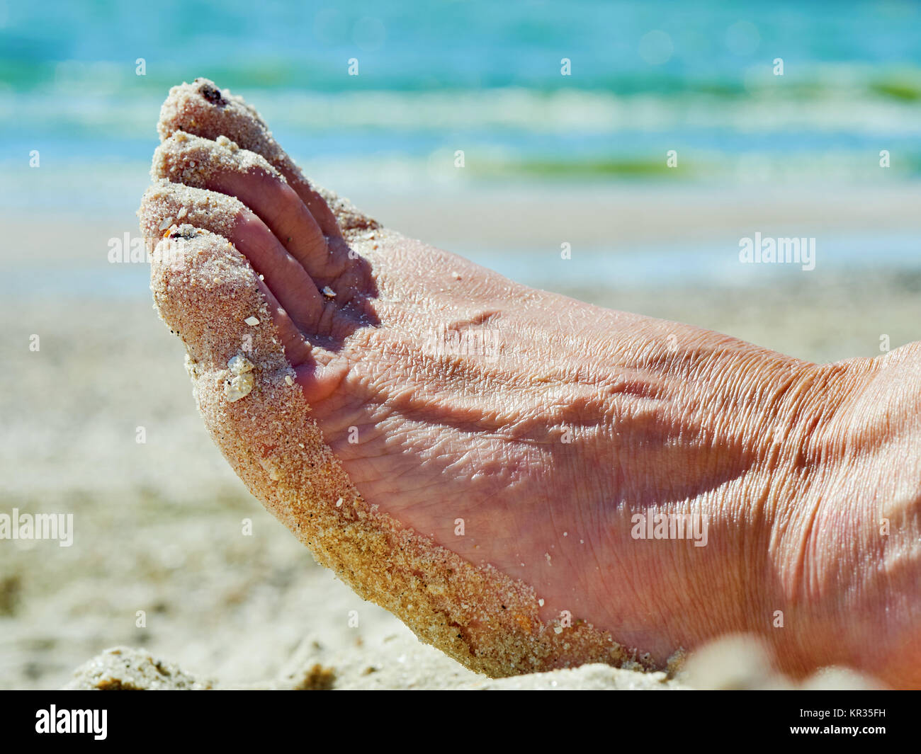 Foot in the sand on the beach Stock Photo - Alamy
