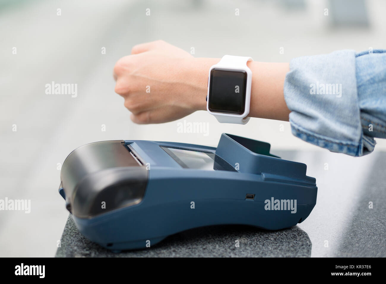 Female customer paying through smart watch by NFC Stock Photo - Alamy