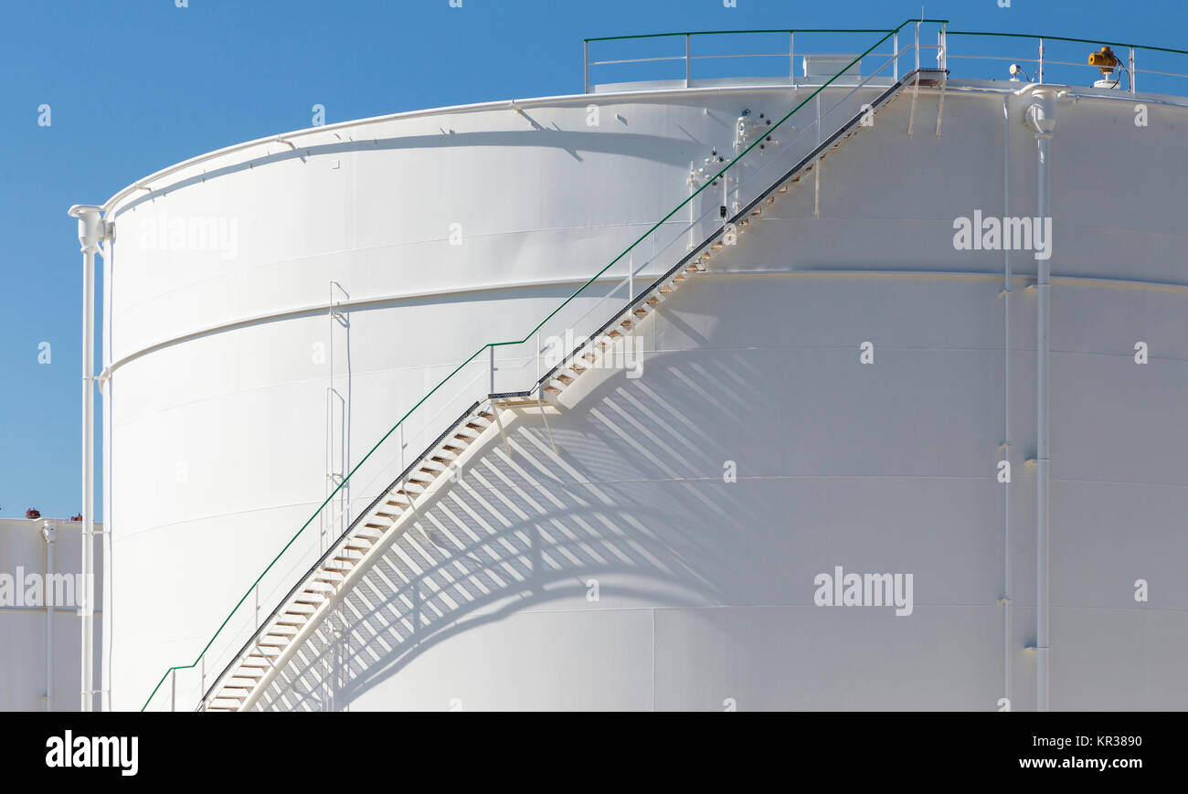 white tanks in tank farm with iron staircase under blue sky Stock Photo ...