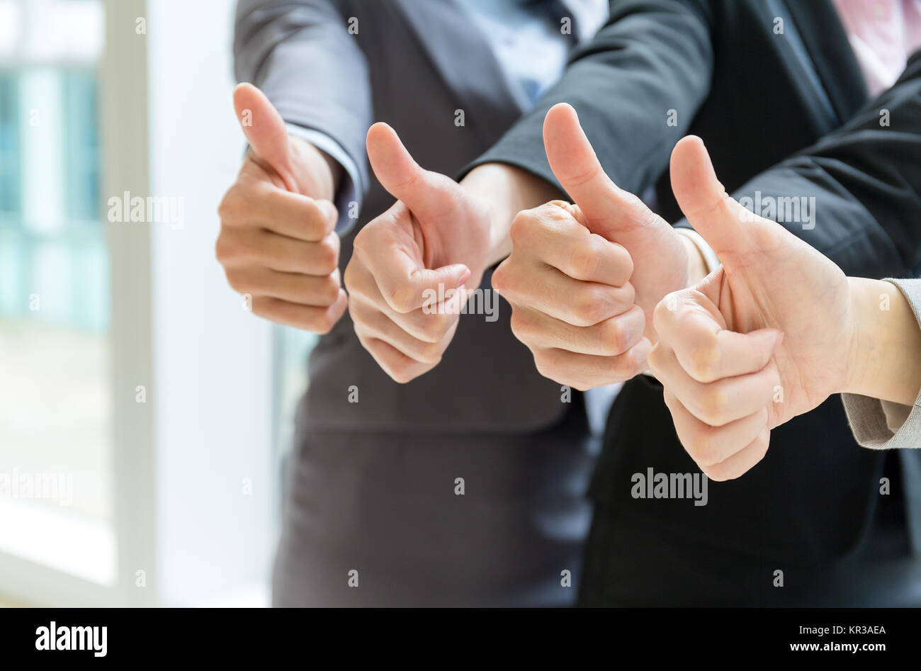 Cheering business people holding many thumbs thumbs up Stock Photo - Alamy