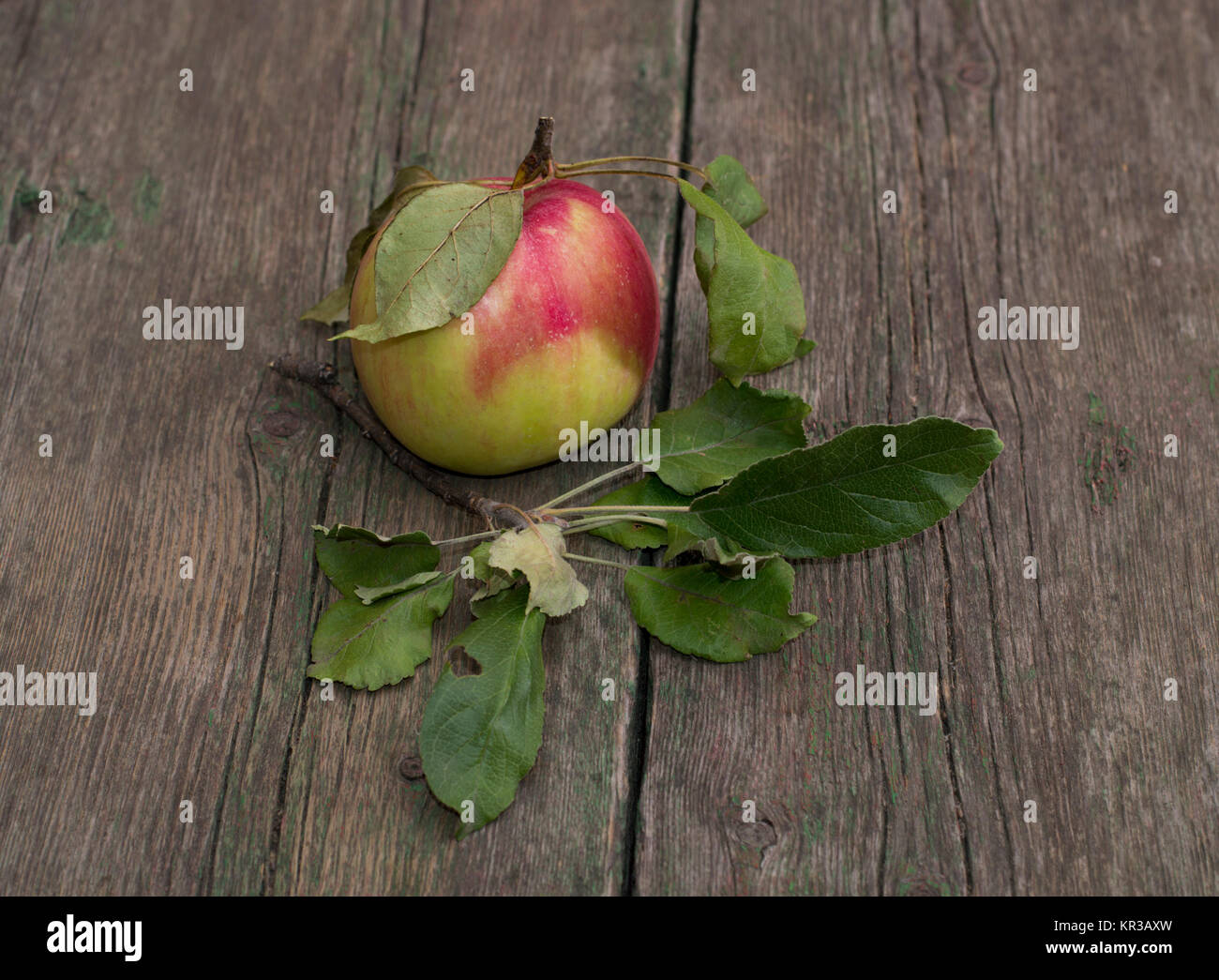 apple with leaves on an old wooden table Stock Photo - Alamy
