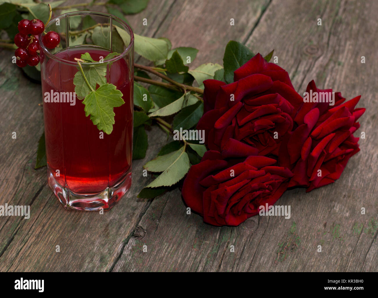 bouquet of red roses and glass with red drink Stock Photo - Alamy